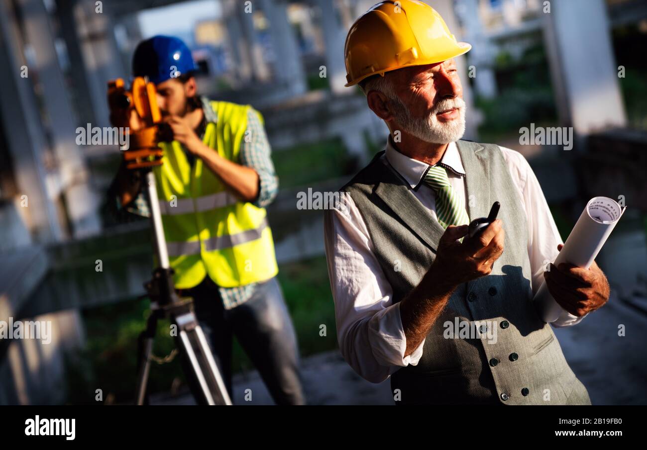 Team of construction engineers, architects working on building site ...