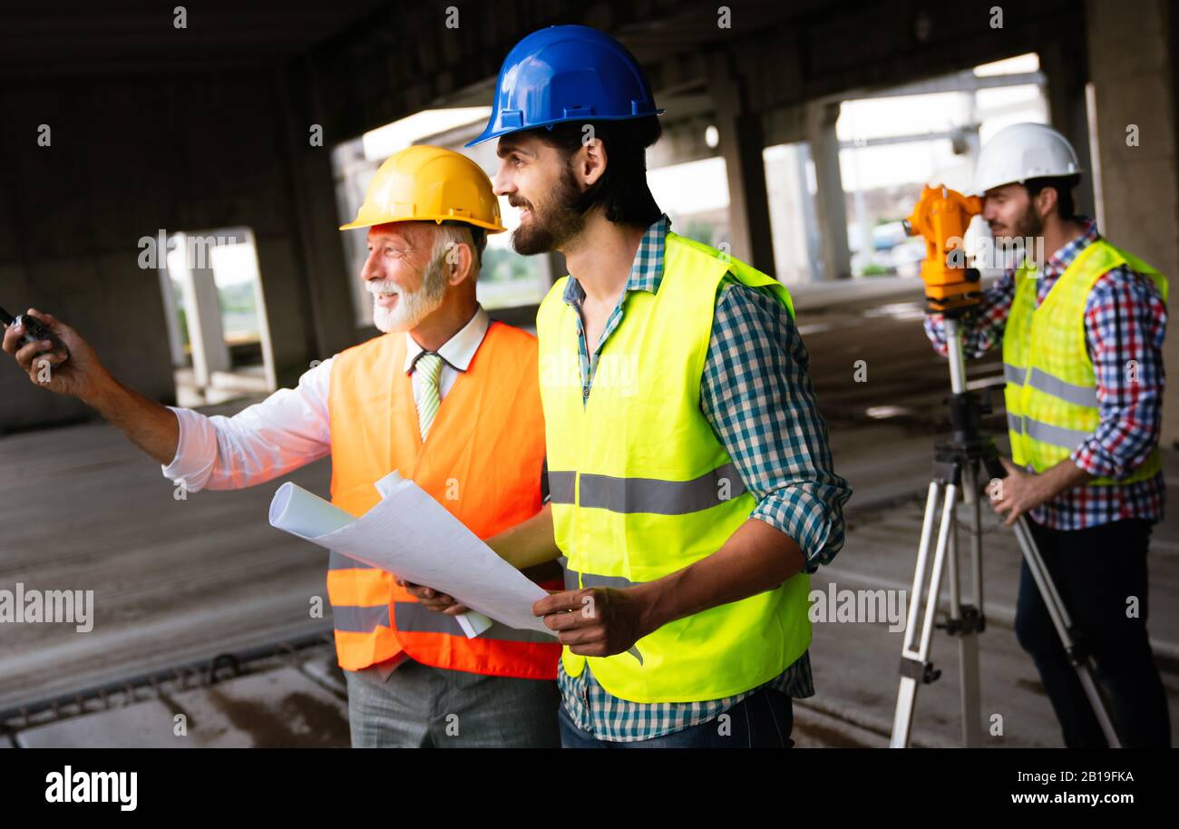 Two satisfied engineers talking at building site with construction ...