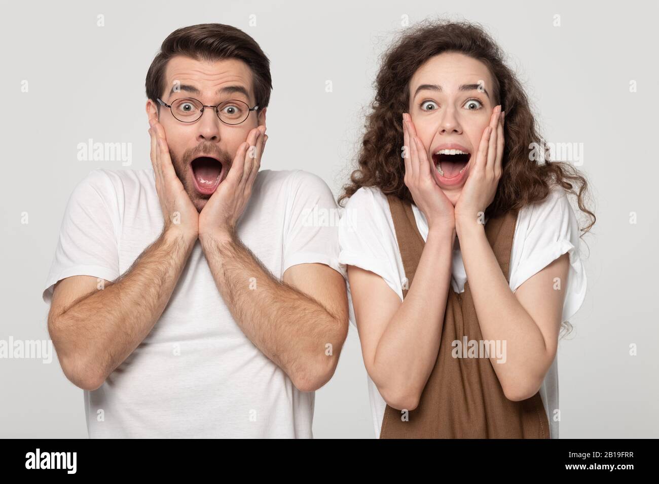 Astonished millennial guy and woman winners amazed by unbelievable news ...