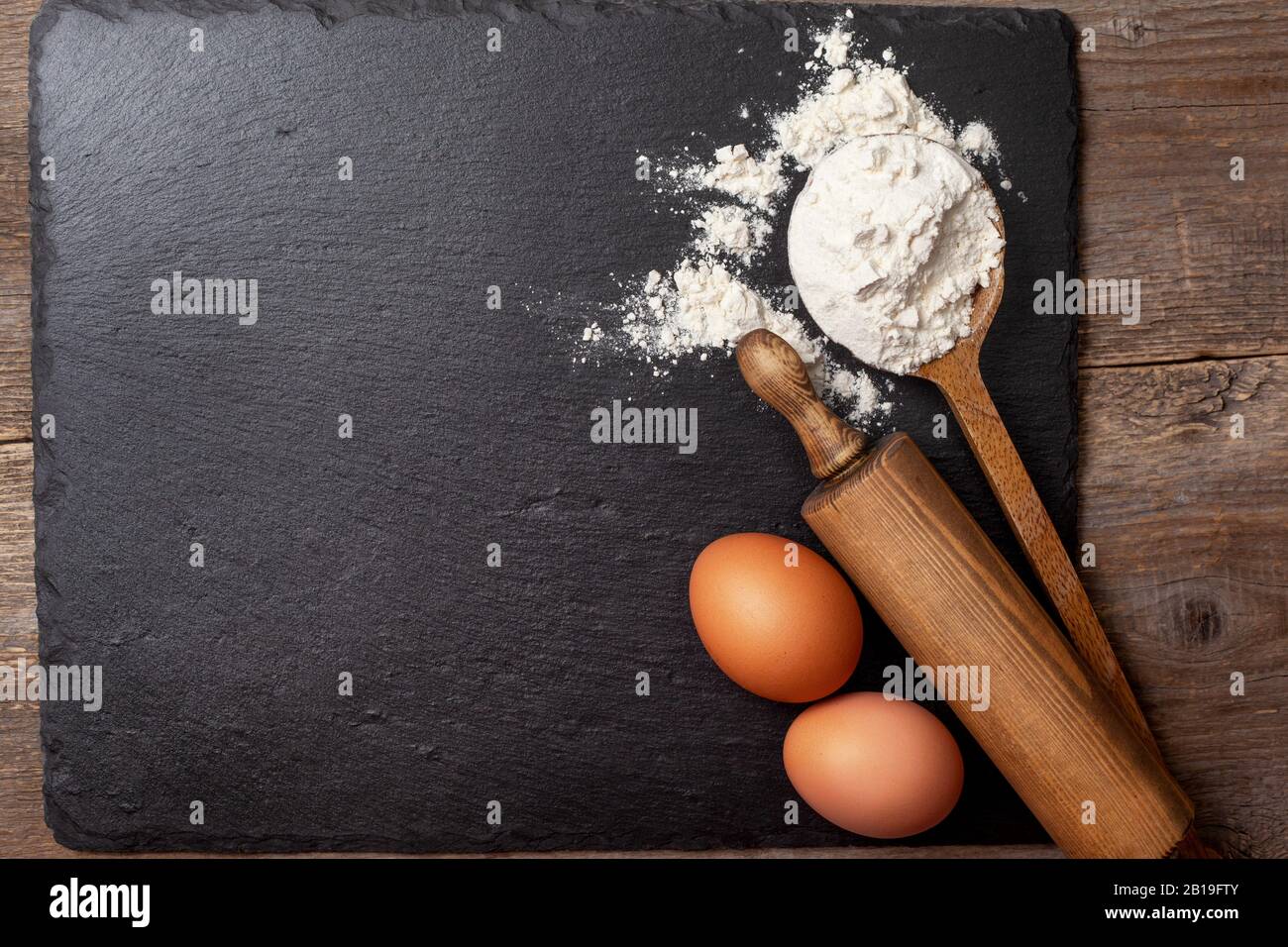 Baking background with eggs and flour on a black background. view from ...