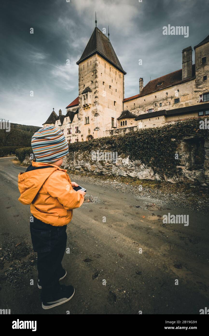 little boy is standing in front of a castle Stock Photo - Alamy