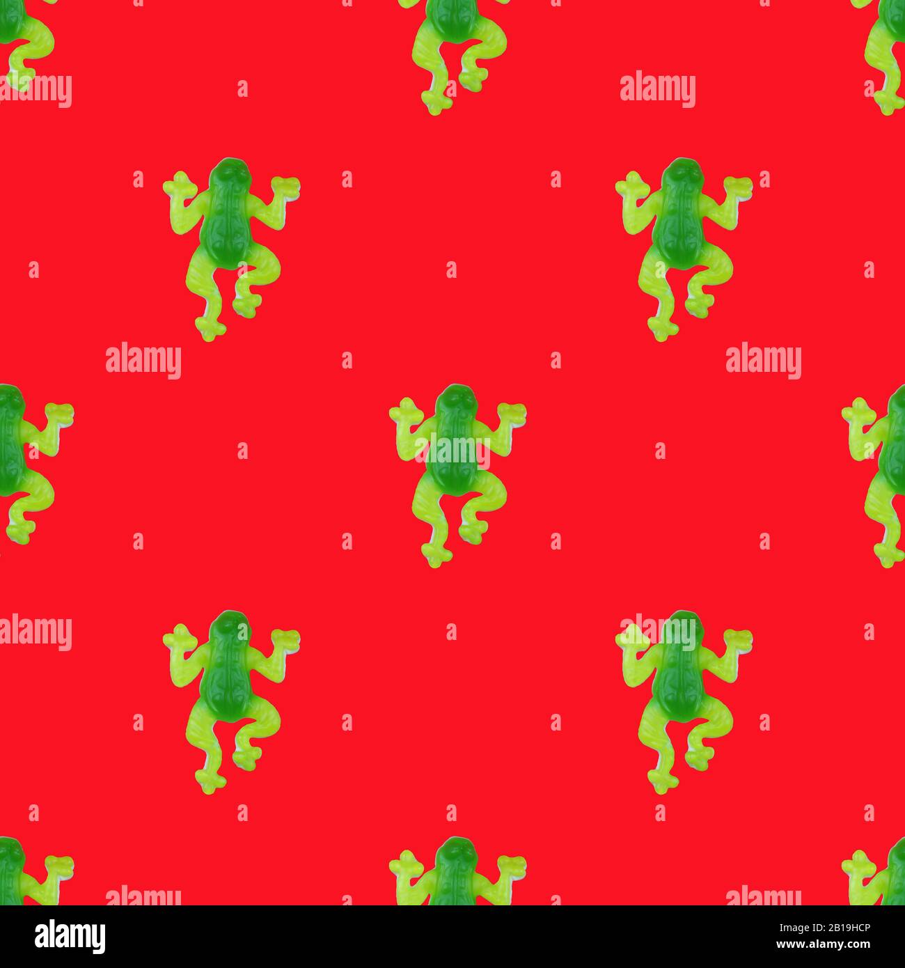 pattern with green frogs candy on red background. Flat lay, top view ...