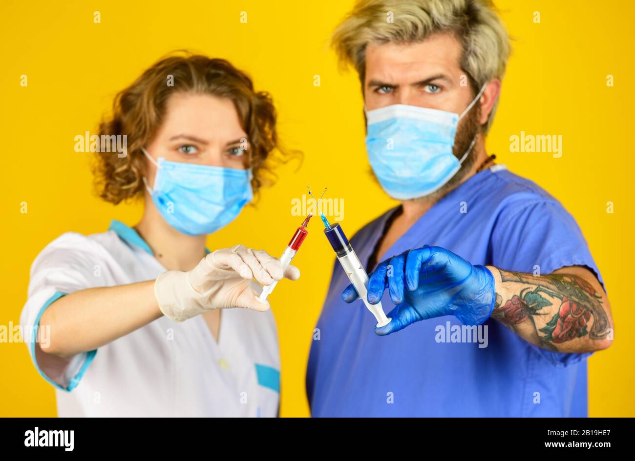 medical couple. virus remedy injection. doctors wear respirator mask ...