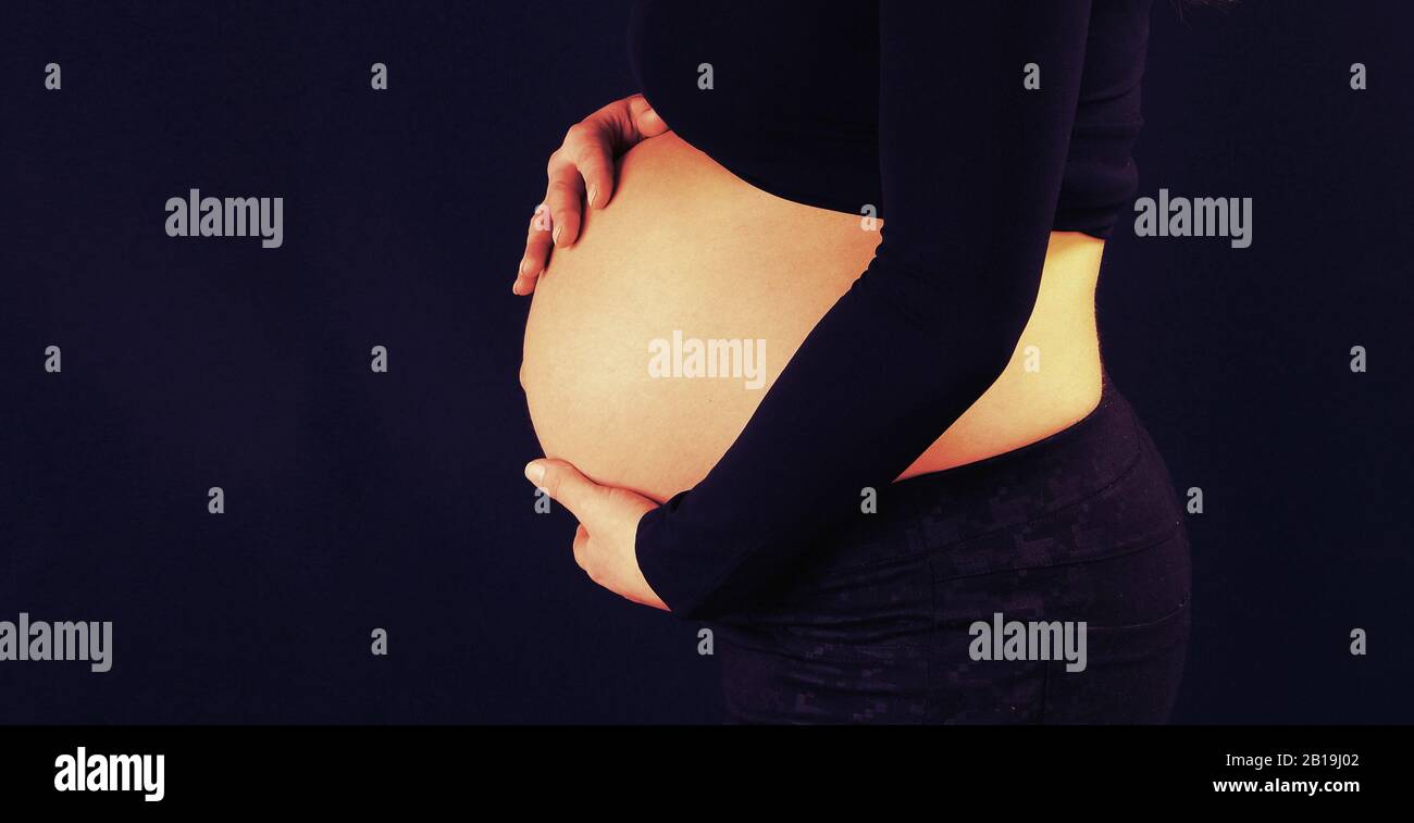 Pregnant woman in an advanced state of pregnancy with her hands on her ...