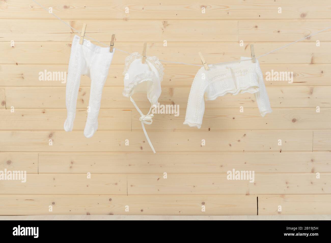 Baby clothes hanging on a rope with clothespins Stock Photo - Alamy