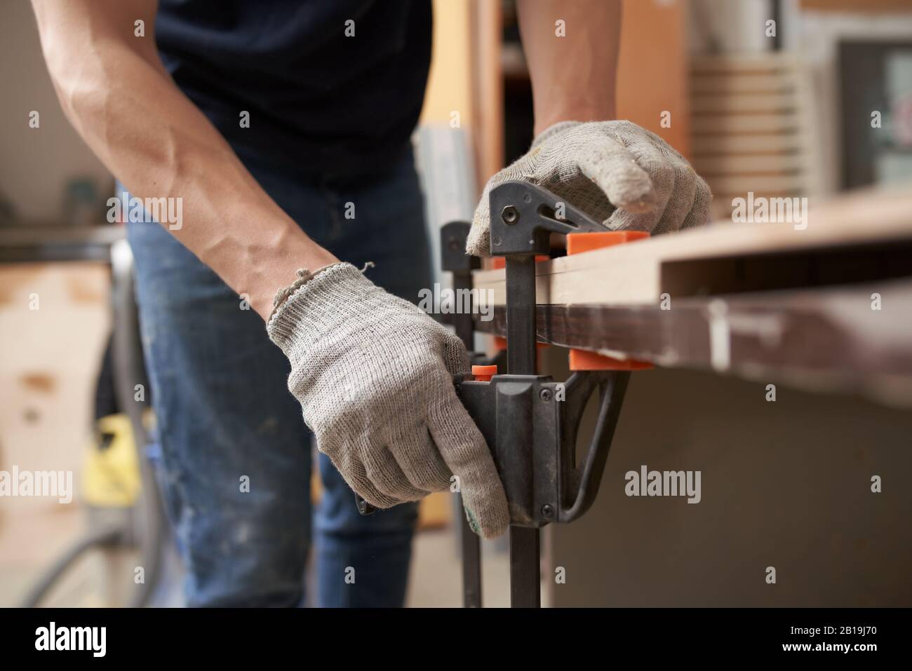 Male joiner in gloves clamps board in vice at workshop , close-up Stock ...