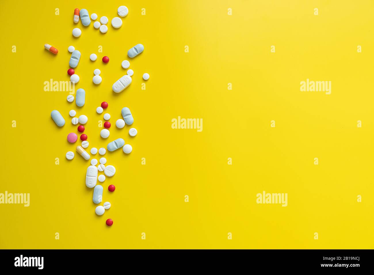 Many different colored tablets pills bright yellow background. Health ...