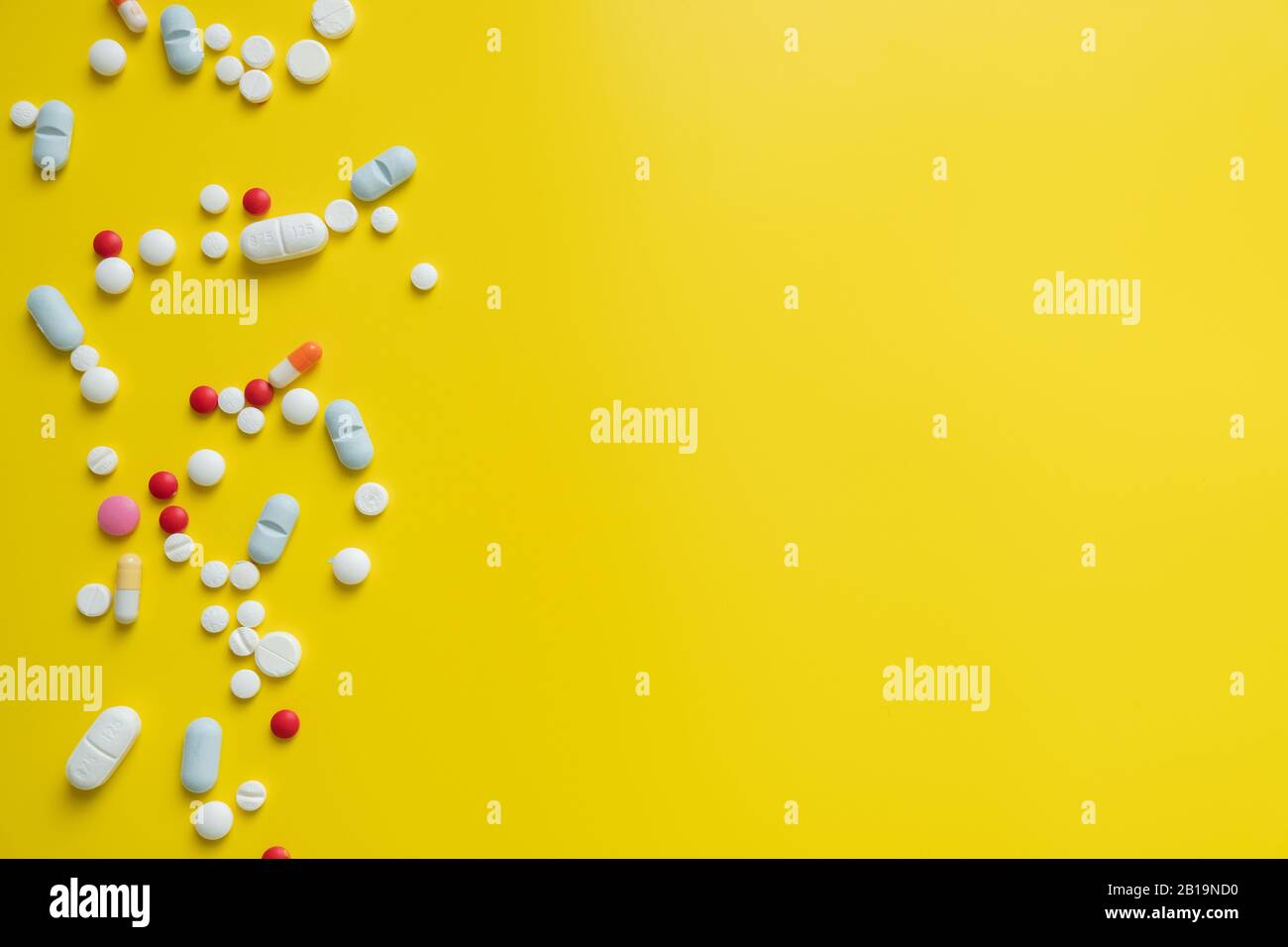 Many different colored tablets pills bright yellow background. Health ...