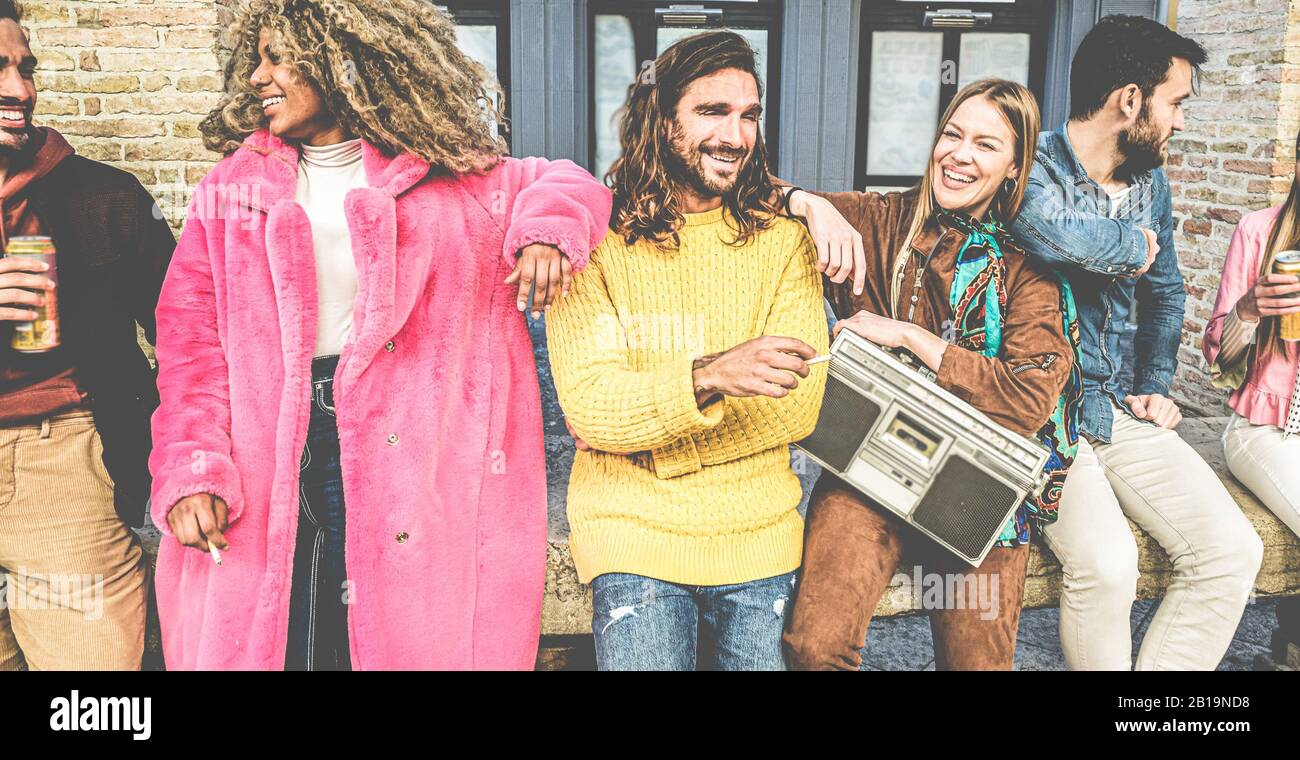 Trendy people making party outdoor drinking beer, smoking cigarettes ...