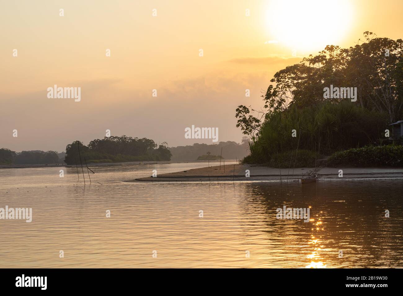 Amazon rainforest sunset during a boat trip with a reflection of the ...