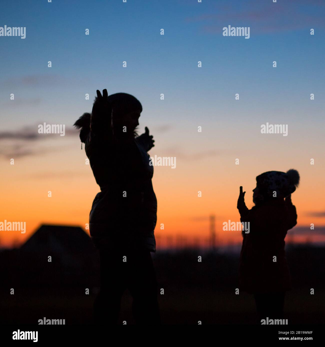 mom and daughter cuddle happily during sunset Stock Photo - Alamy