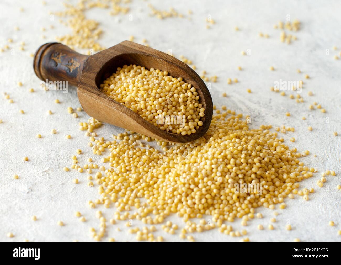 Raw dry hulled millet with a spoon close up Stock Photo - Alamy