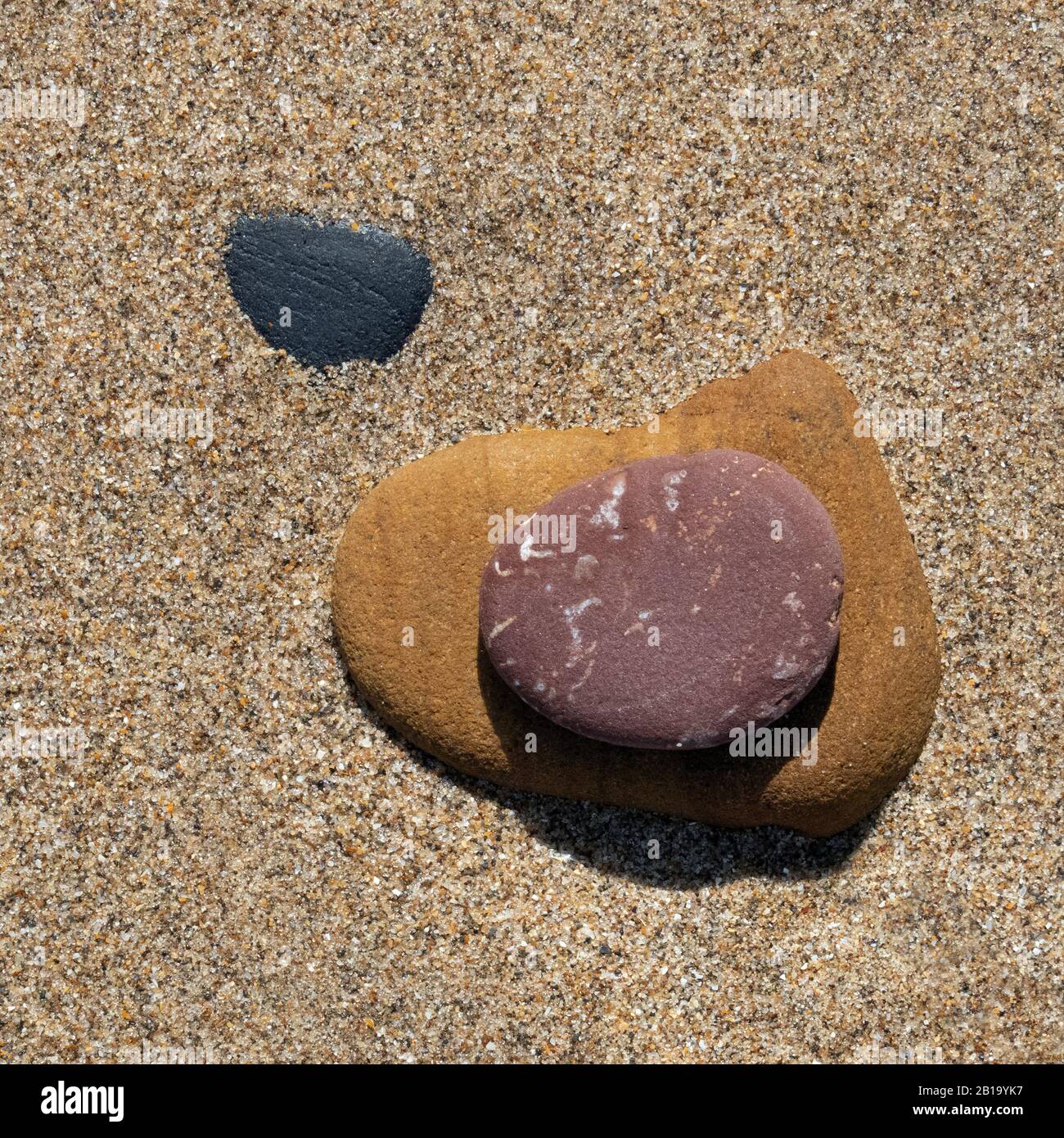Colour photograph of coastal stones on beach smoothed and rounded by ...