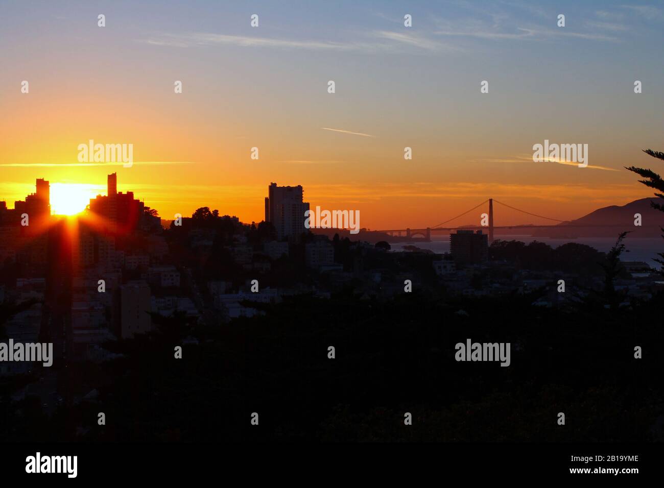 The sunset with the Golden Gate and the buildings Stock Photo - Alamy