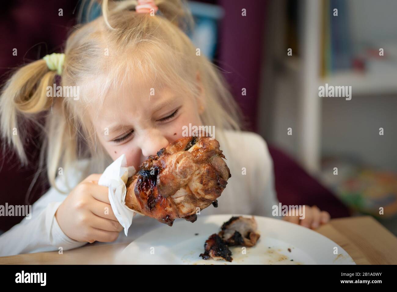 Cute adorable caucasian blond little girl portrait enjoy eating roasted ...