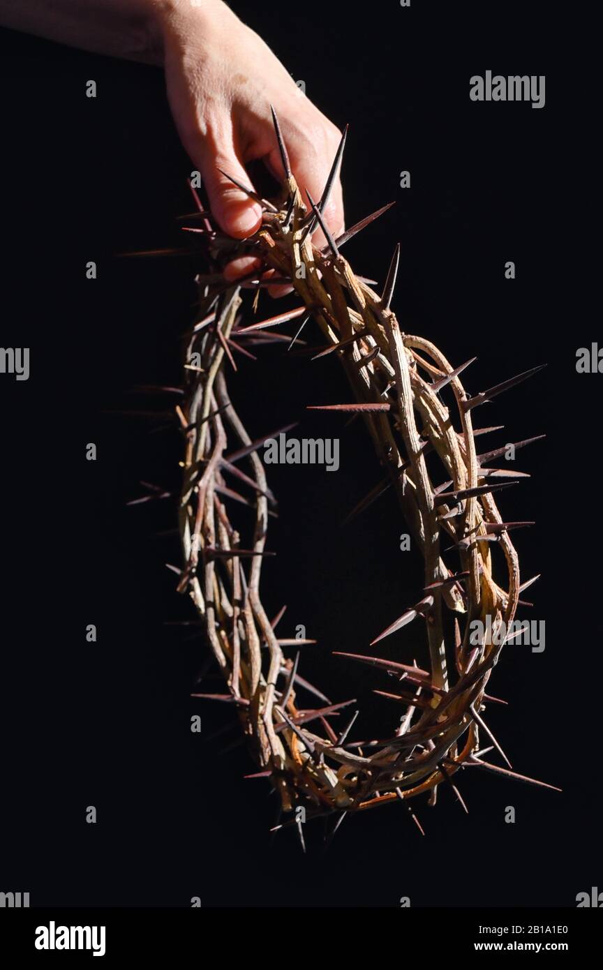 Hand and Crown Of Thorns On A Black Wooden Background Stock Photo - Alamy