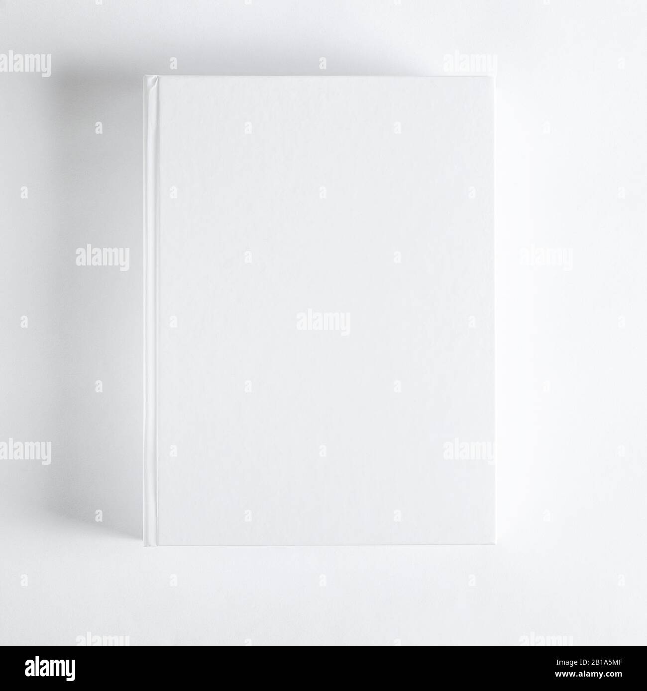 Mockup of closed blank square book at white textured paper background ...