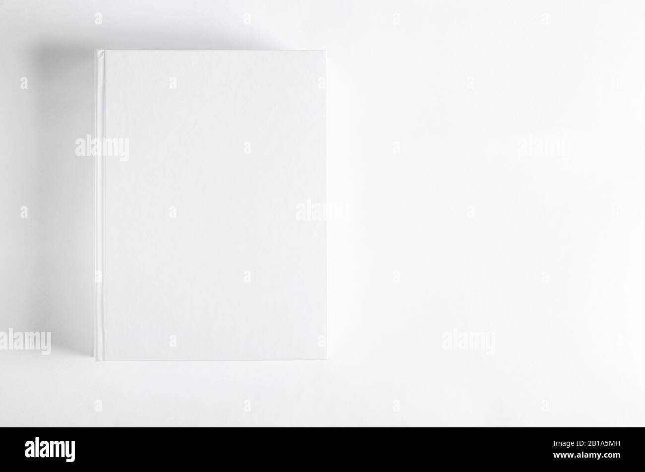 Mockup of closed blank square book at white textured paper background ...