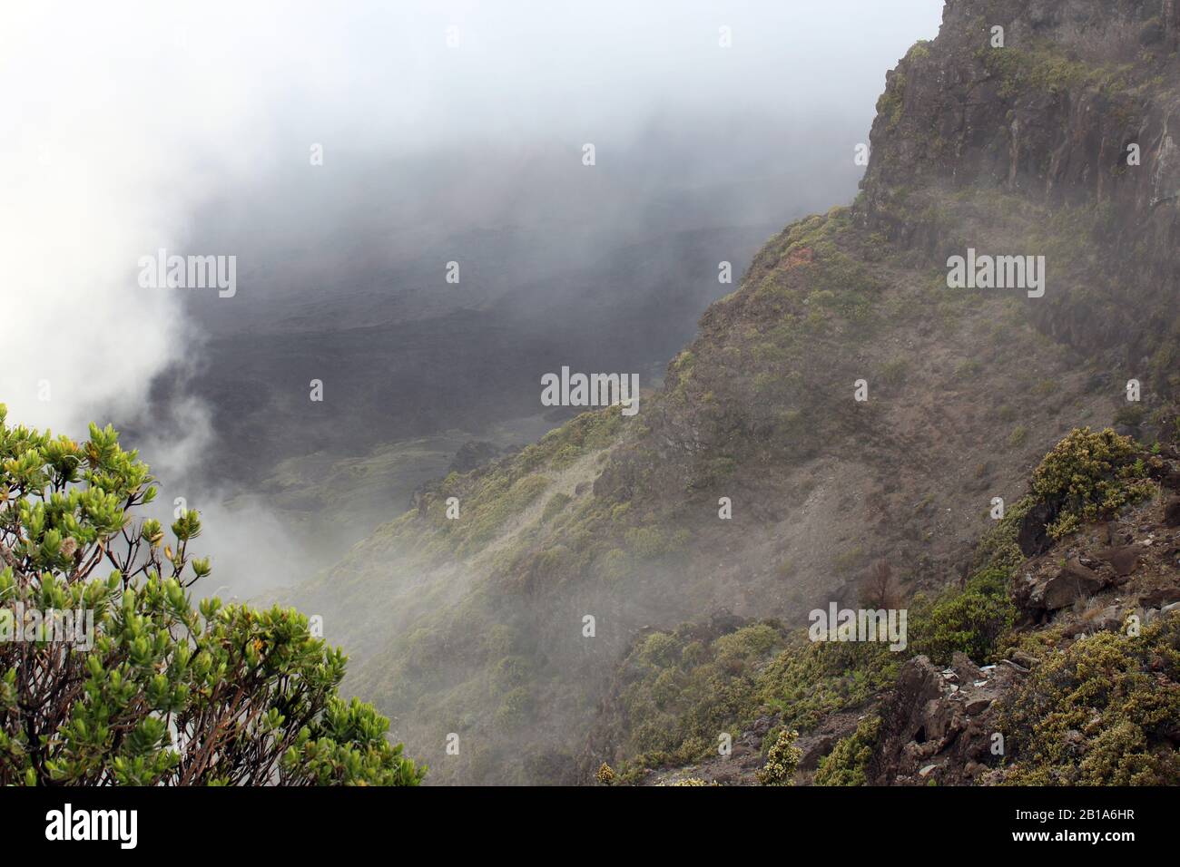 Clouds partially obscuring a crater on the dormant volcano Haleakala at ...