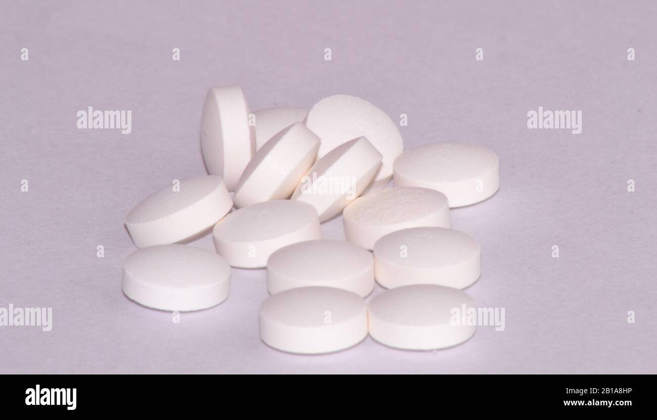 Round, white tablets on a white background Stock Photo - Alamy