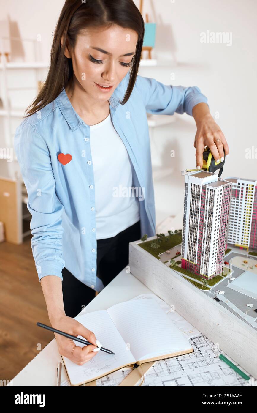 Closeup image of beautiful professional architect measures scale of a ...