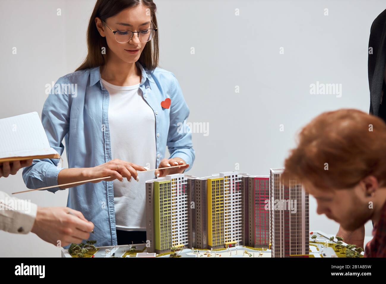 young woman in stylish blue shirt and white top learning to measure ...