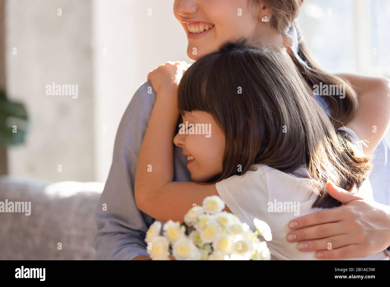 Loving little daughter hug mommy greeting presenting flowers Stock ...