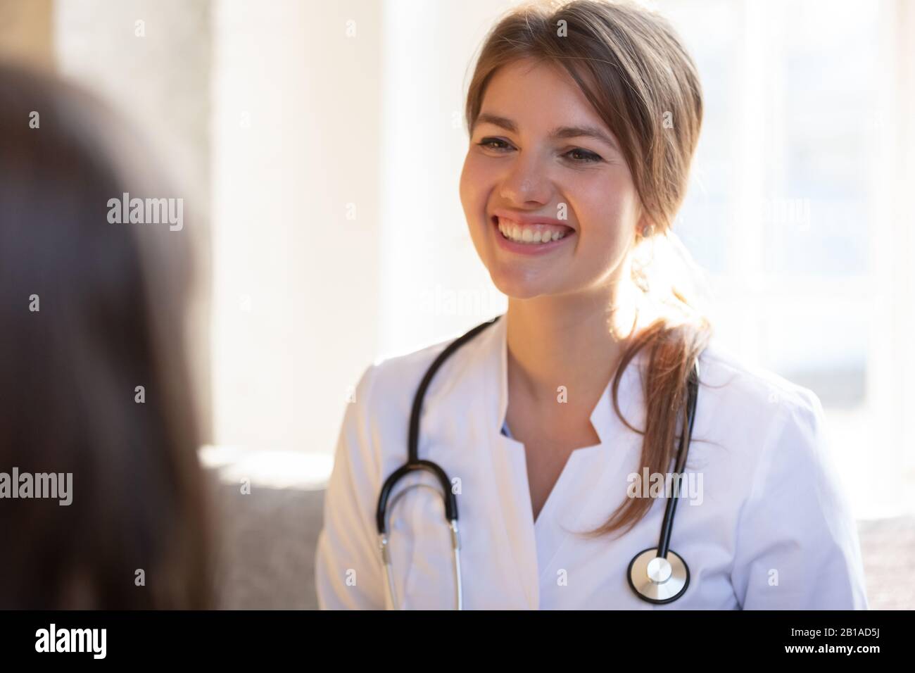 Smiling female doctor with stethoscope listen to patient Stock Photo ...