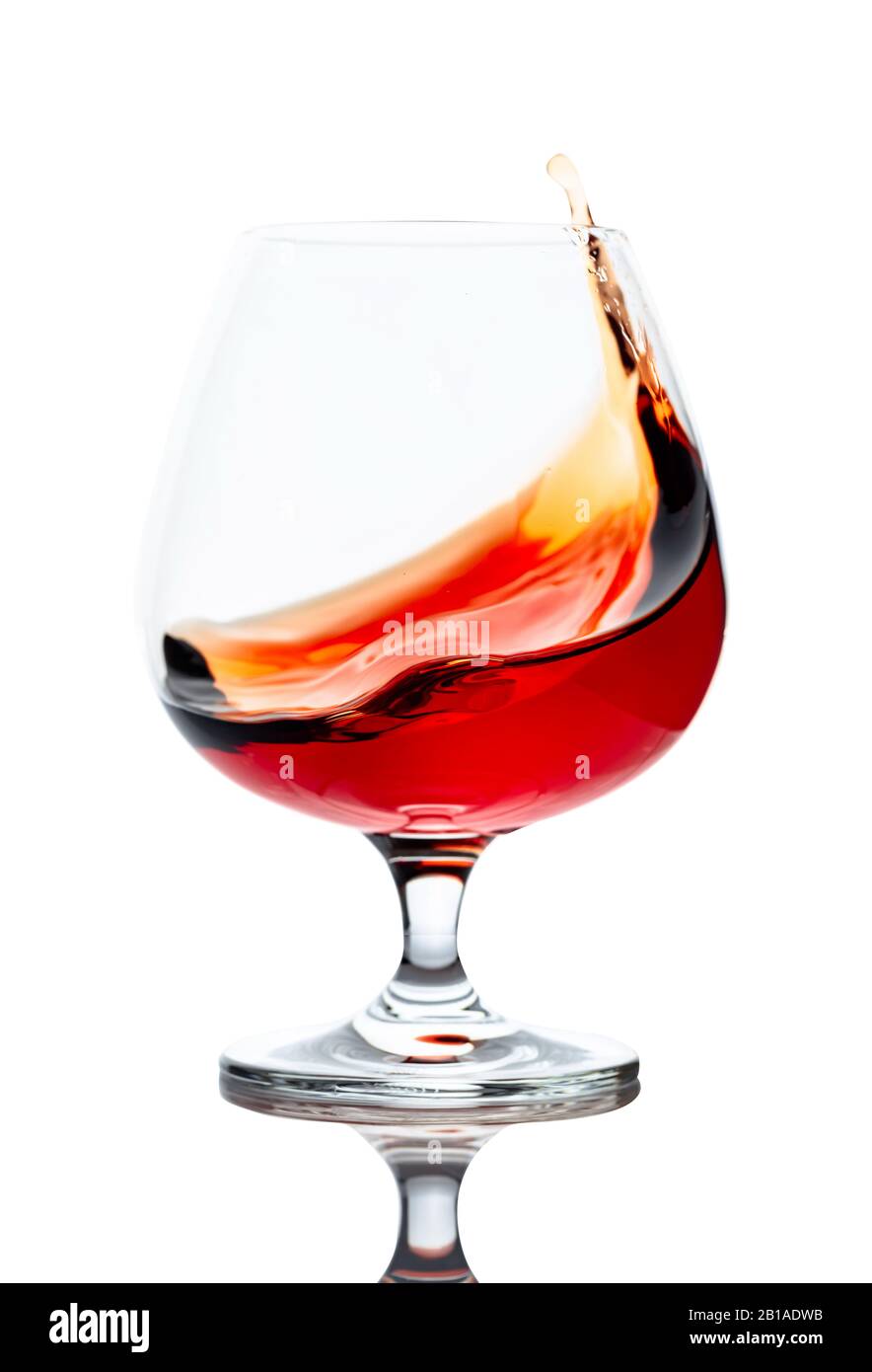 Splash of cognac in glass, isolated on white background. Saved clipping ...