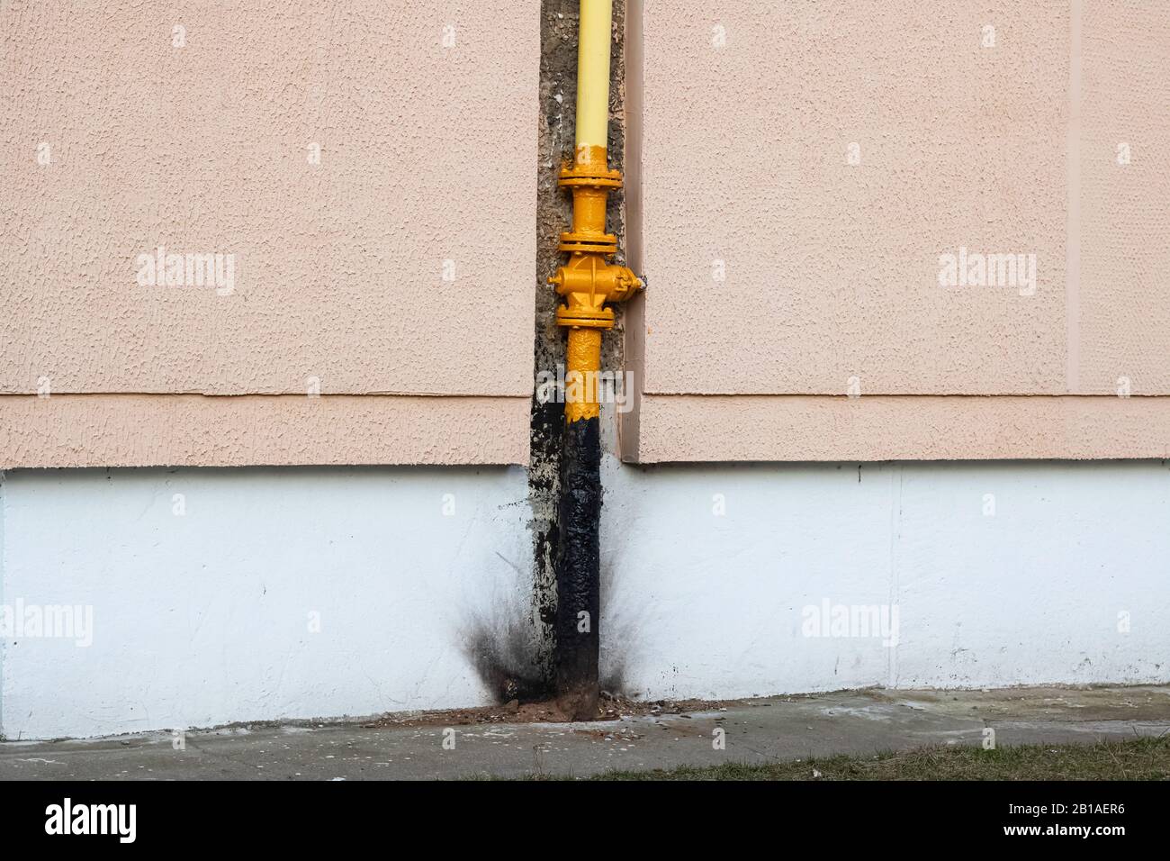 Yellow water pipe on a house wall Stock Photo - Alamy