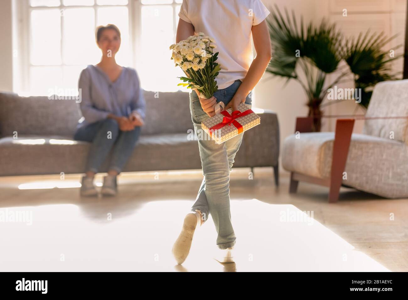 Caring child hide presents making surprise for young mom Stock Photo ...