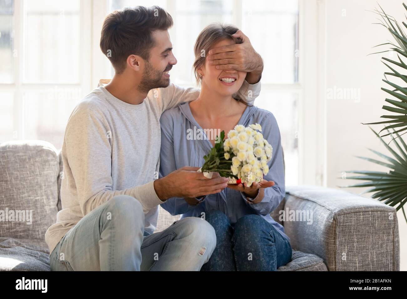 Loving husband make birthday surprise to amazed wife Stock Photo - Alamy