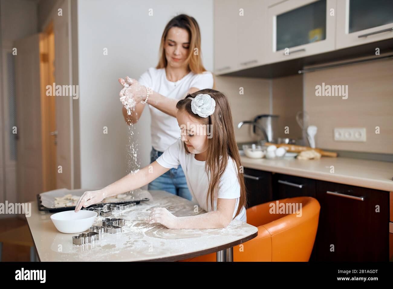 little girl and her mother having flour party, girl likes to help her ...