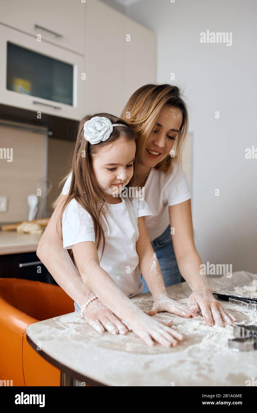 little cheerful girl is keen on cooking process, kid is fond of cooking ...