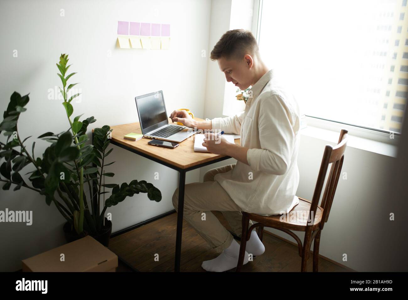 young journalist writing a report at home. close up side view photo ...