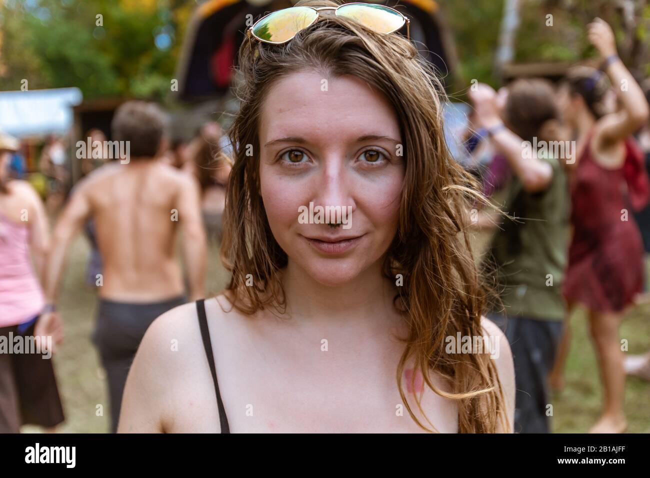 A close up head shot of a natural woman with unkempt brunette hair and ...