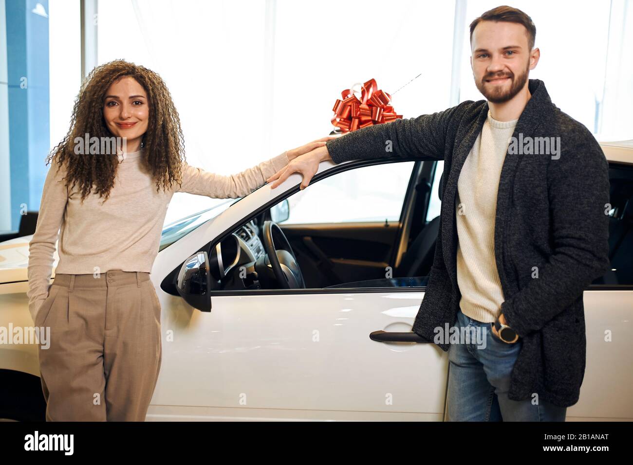 Young loving couple standing in front of their new automobile Handsome ...