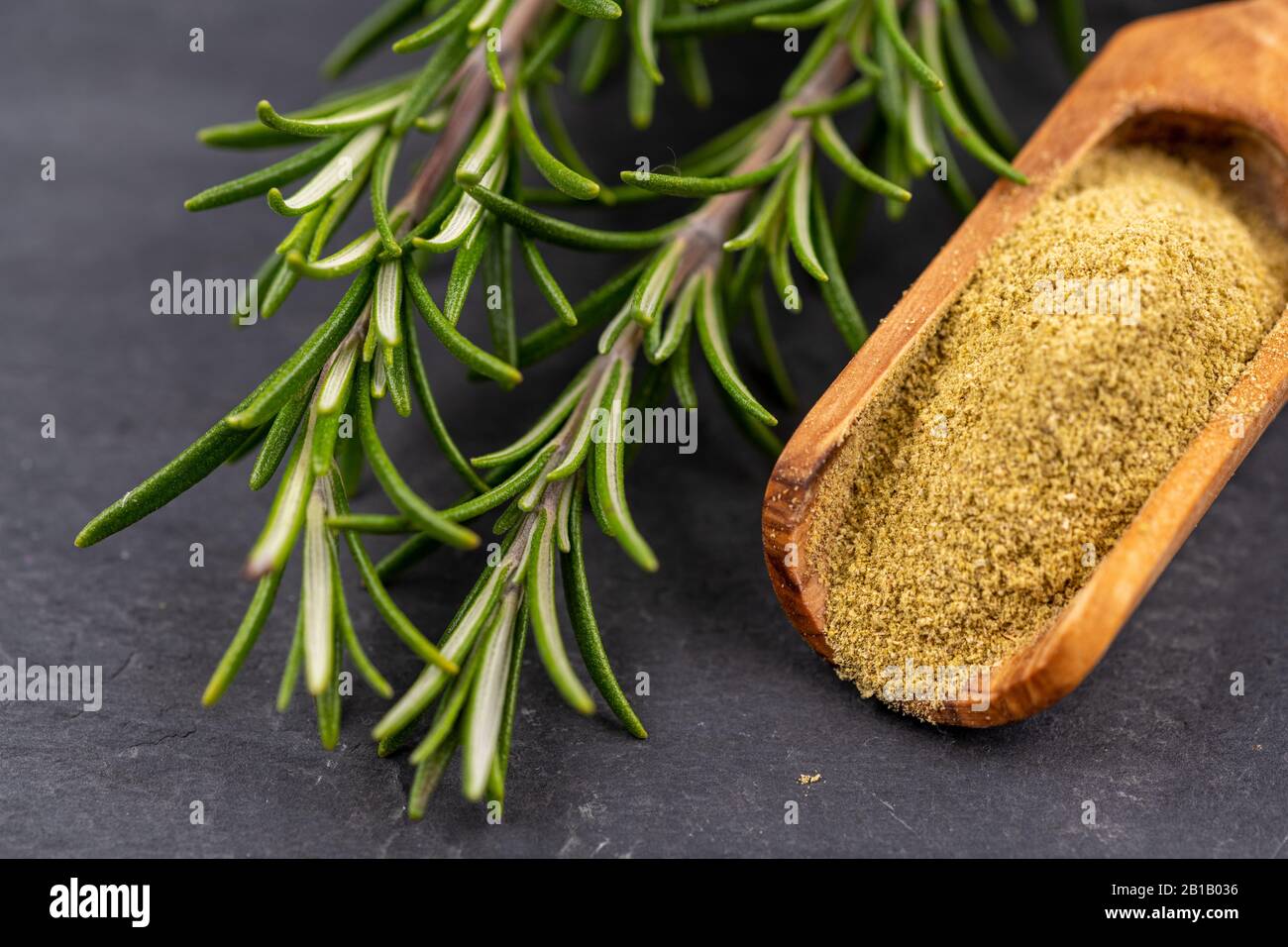 Extreme close-up view of fresh rosemary twigs and a spice shovel with ...