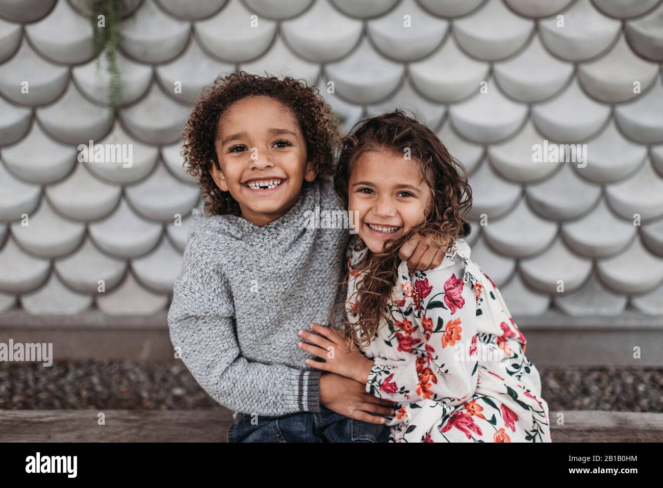 Cute siblings smiling and laughing while hugging Stock Photo - Alamy