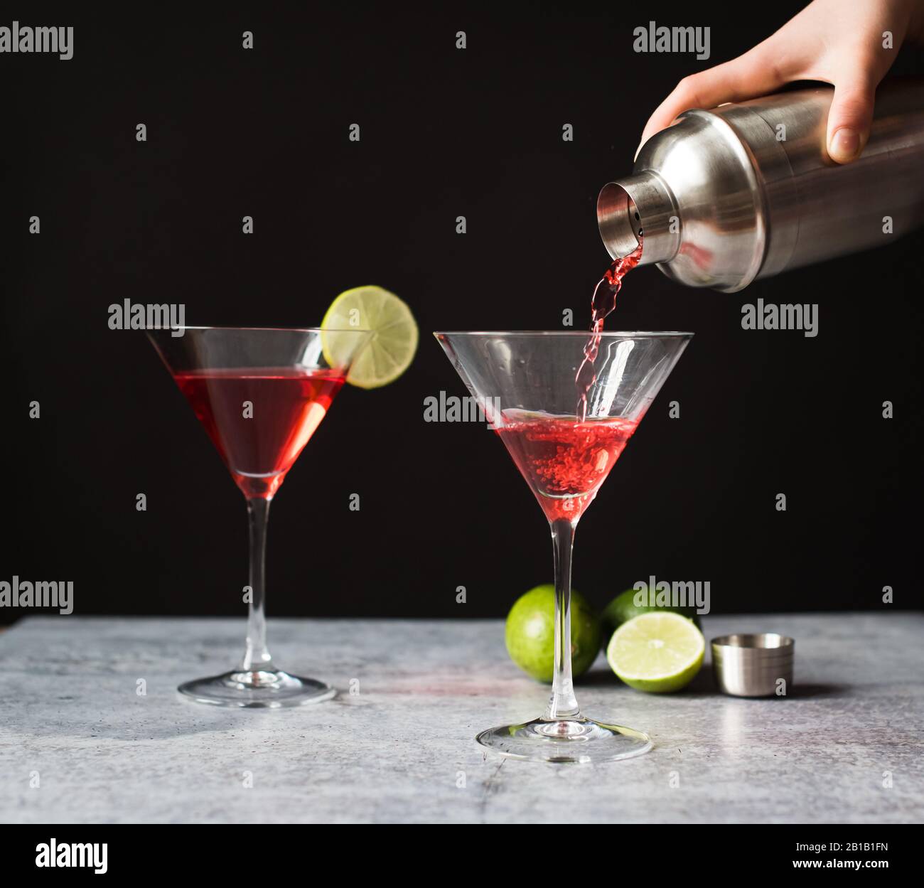 Hand pouring cosmopolitan martini into glass from a shaker Stock Photo ...