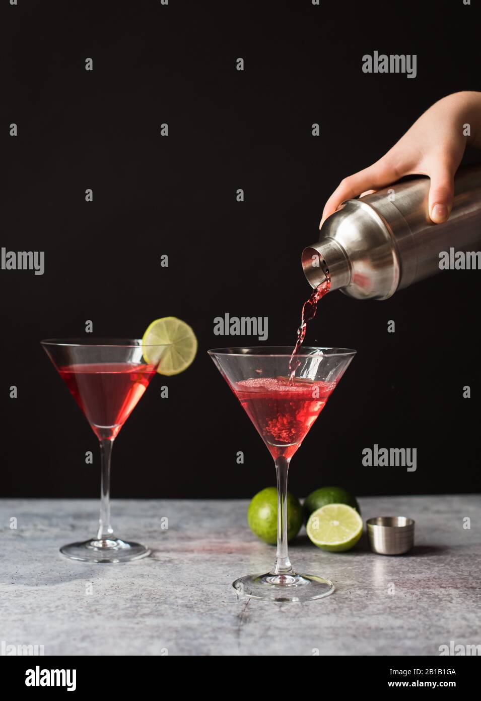 Hand pouring cosmopolitan martini into glass from a shaker Stock Photo ...