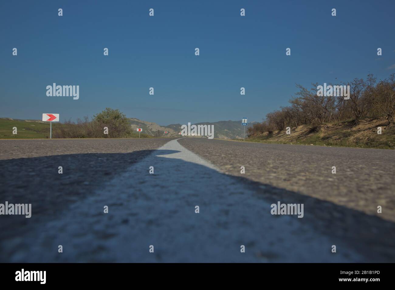 An empty road with single solid white line road marking. Background ...