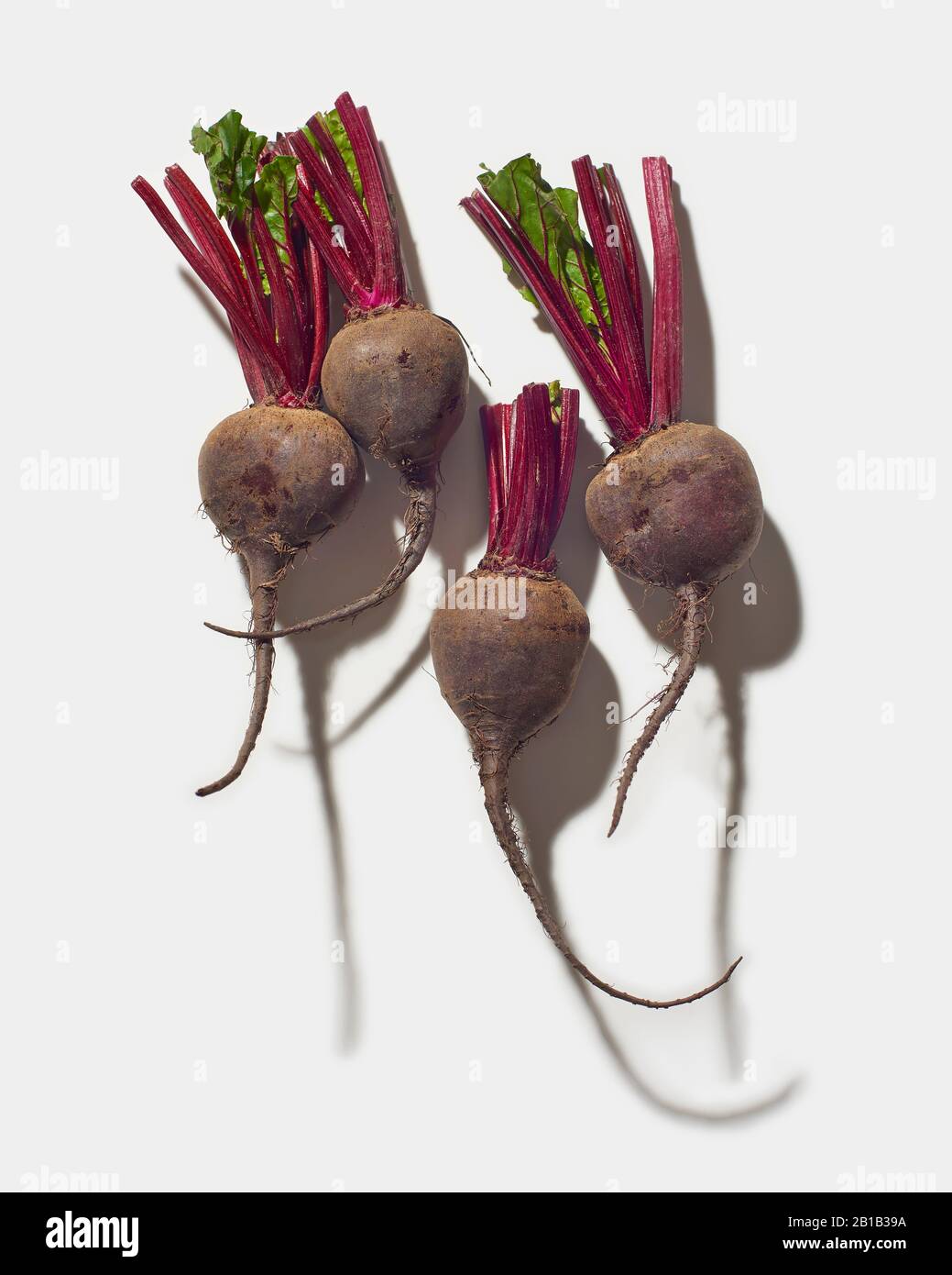 Four red beets on white Stock Photo - Alamy