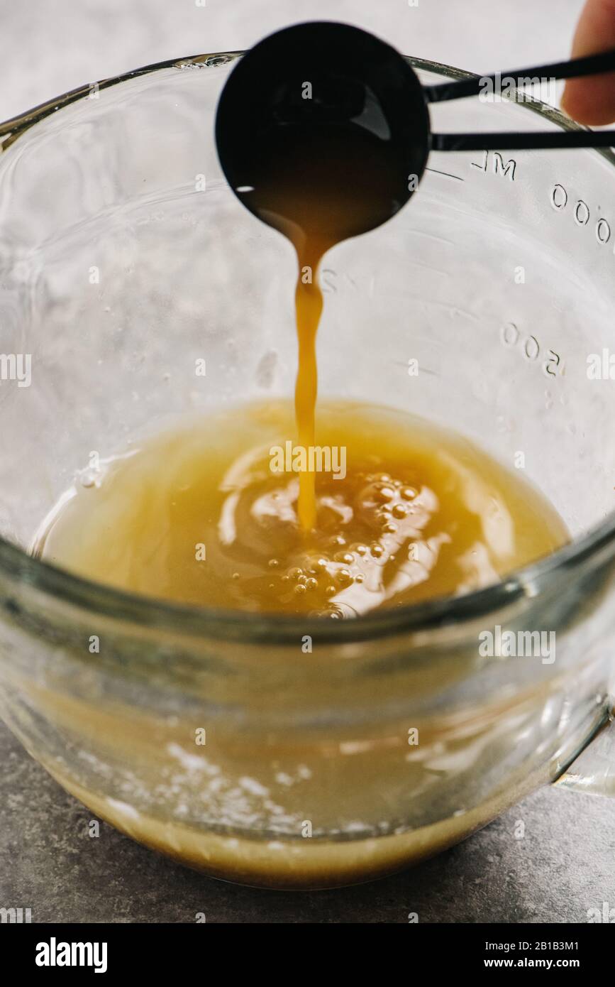 Adding measured liquid ingredients into a recipe Stock Photo - Alamy