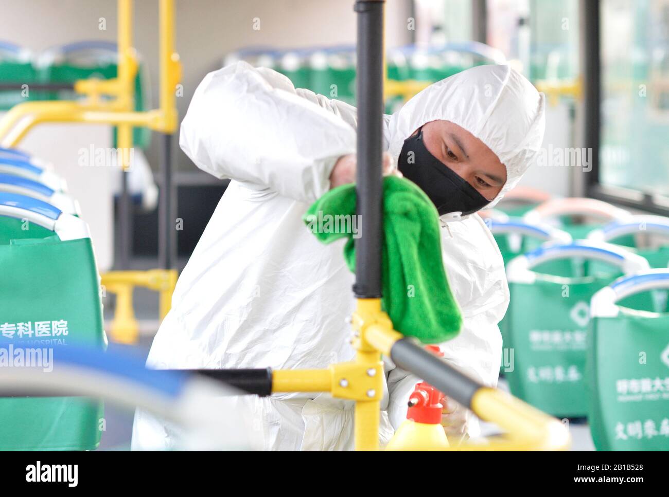 Hohhot City, China. 24th Feb 2020. A Chinese worker disinfects a bus to ...