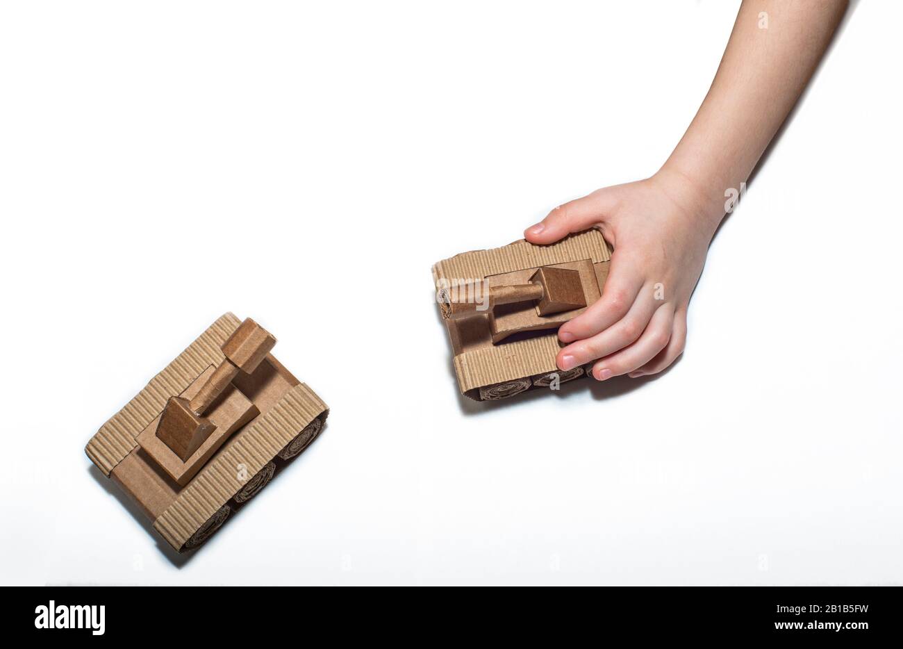 children's hands play with tanks. two toy tanks made by children from ...