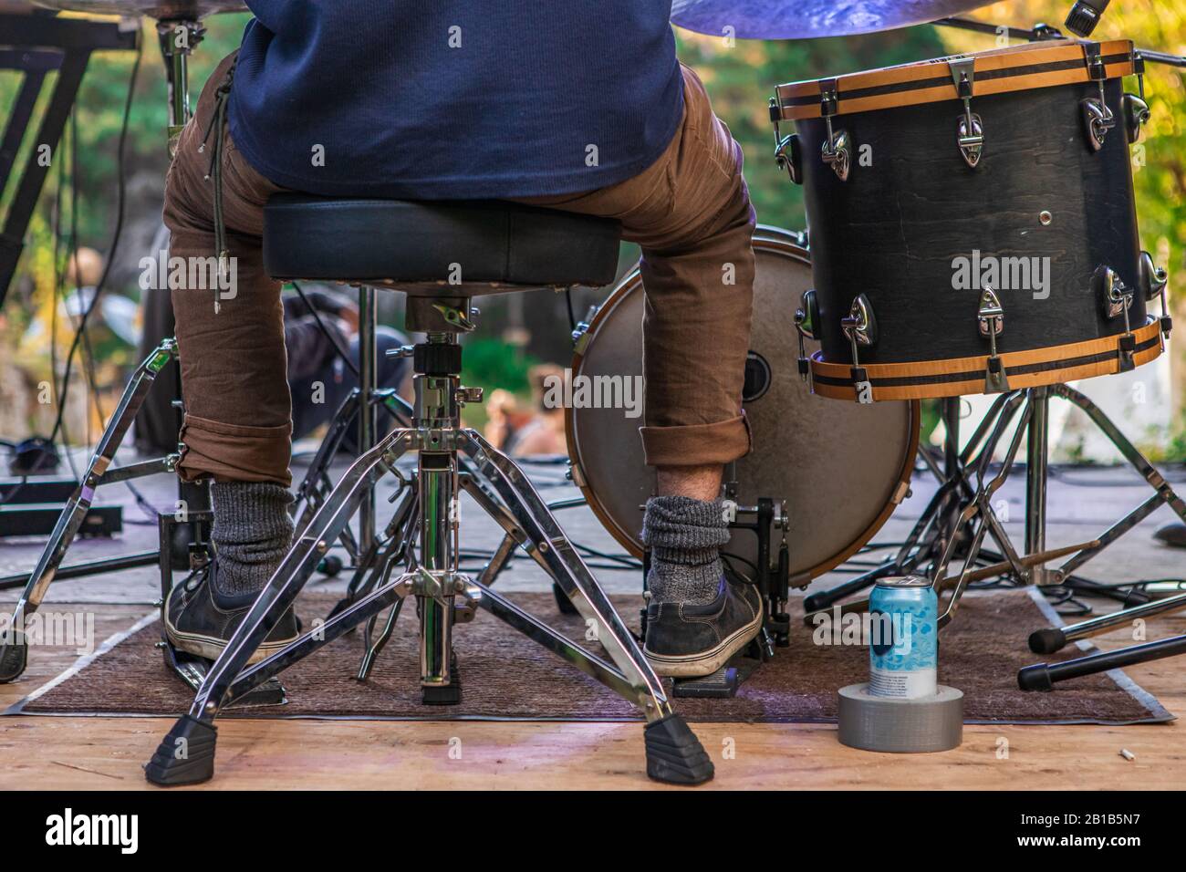 A closeup and rear view in selective focus on back of legs of drummer ...
