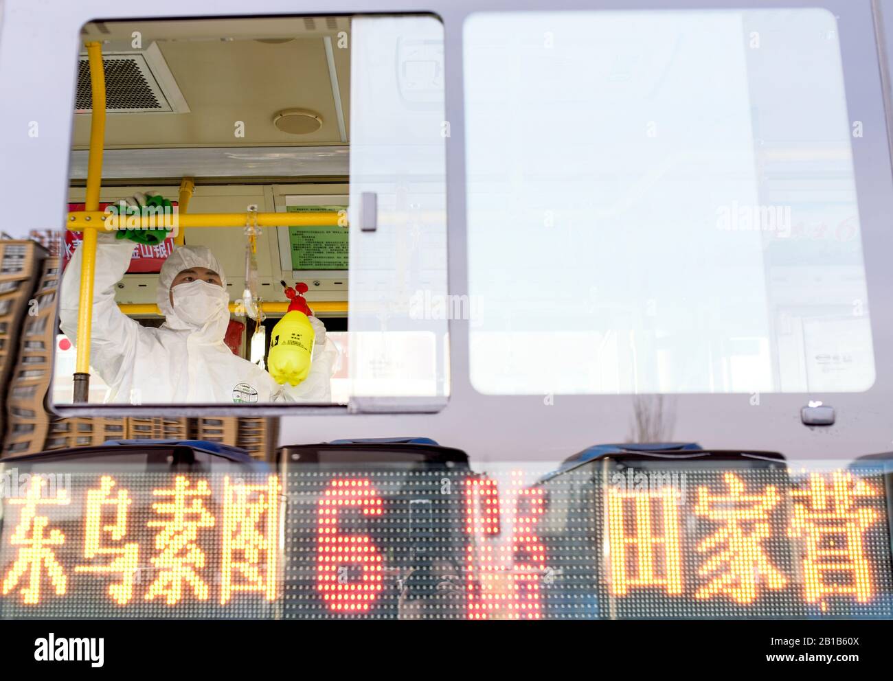 Hohhot City, China. 24th Feb 2020. A Chinese worker disinfects a bus to ...