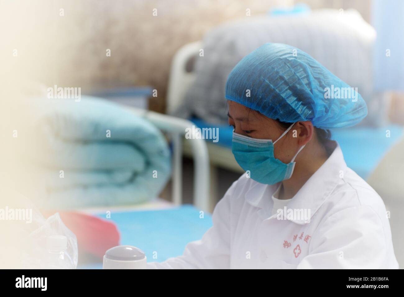 A masked Chinese medical worker is on duty in the observation room at a ...