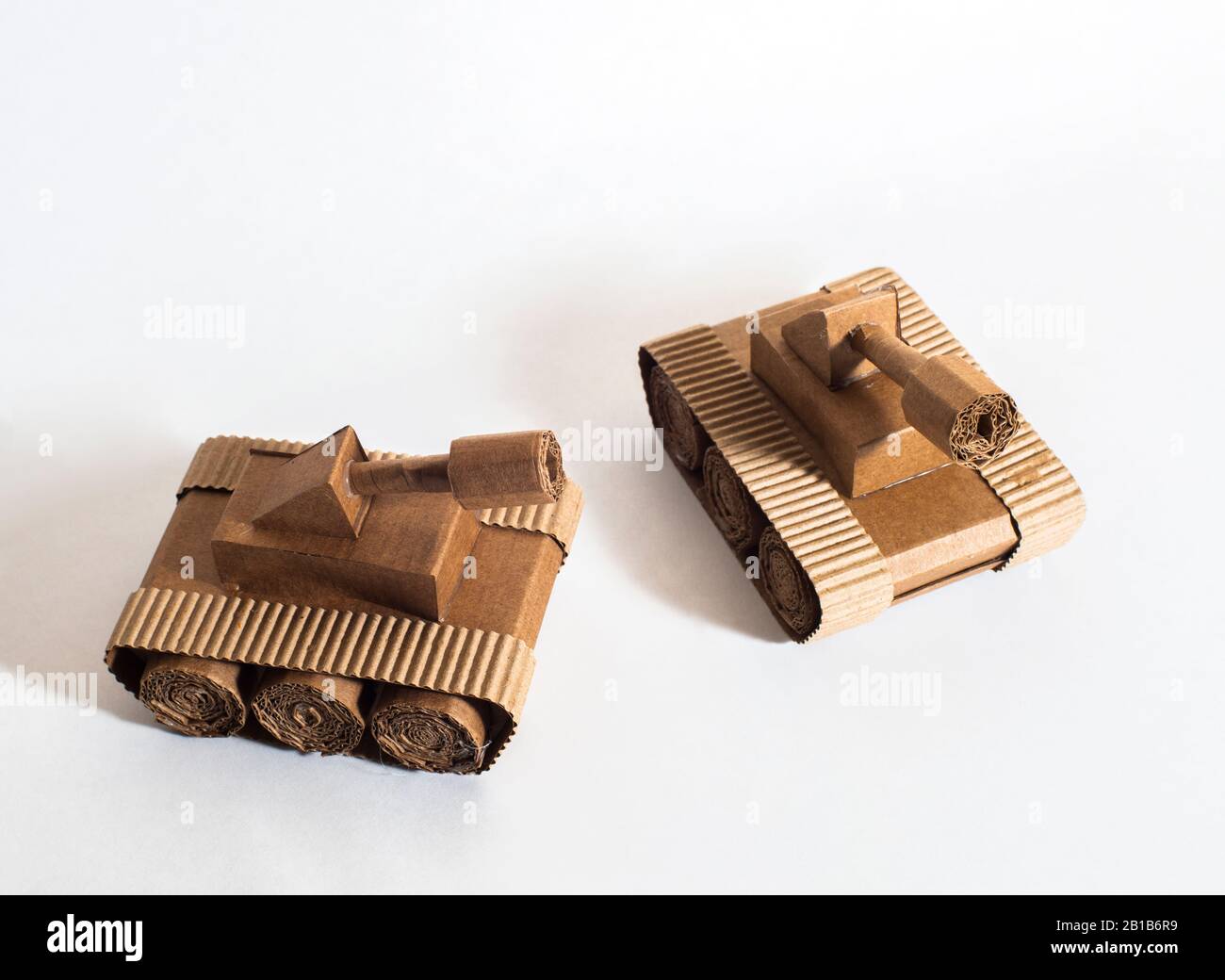 two toy tanks made by children from corrugated cardboard are fighting ...